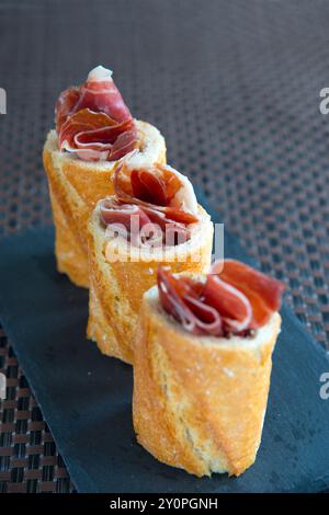 Spanish tapa: rolls of bread stuffed with Iberian ham and tomato sauce ...