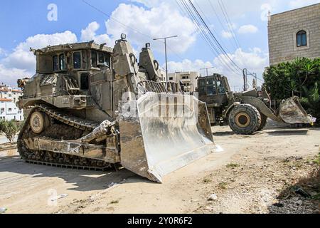 Israeli military bulldozers are seen during a military raid in the Nur ...