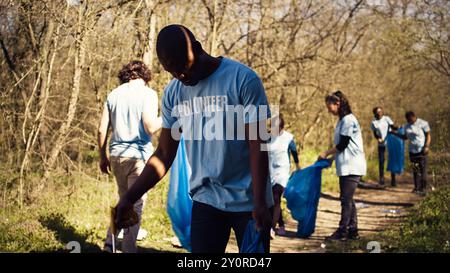 Eco friendly activist grabbing garbage and plastic waste from a forest ...