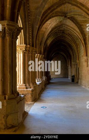 A long, narrow corridor with stone arches and white walls, typical ...