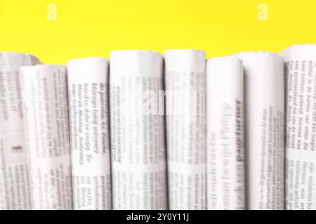 Different newspapers on yellow background Stock Photo - Alamy