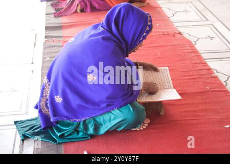 Modestly-dressed woman praying in mosque; Delhi; India; brightly ...