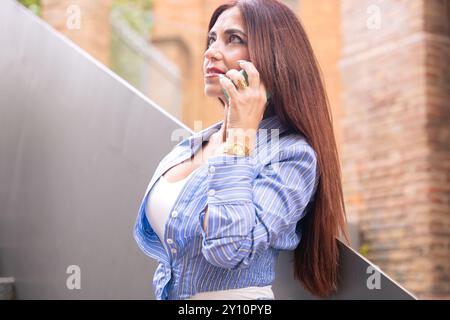 Portrait of beautiful business woman talking on her smartphone and ...