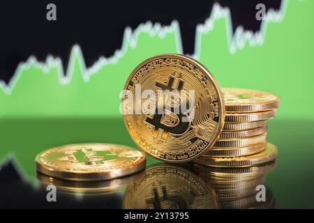 Bitcoin cryptocurrency coin and the green line of a graph are pictured ...