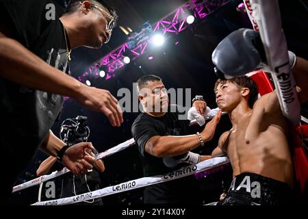 Japanese champion Naoya Inoue, right, listens to his trainer and father ...