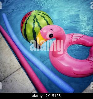 Colorful inflatable flamingos and balls floating in a sunny swimming ...