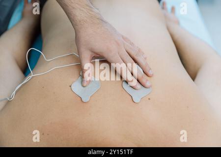 Electrotherapy session with electrodes for back pain relief in a ...