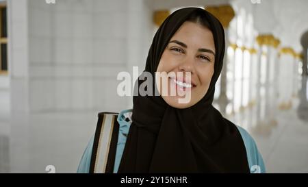 Beautiful hispanic woman wearing islamic hijab holding japanese yen ...