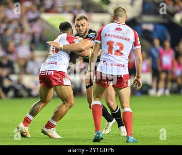 Kaide Ellis of Wigan Warriors is tackled during the Betfred Super ...