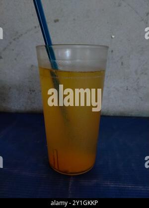Orange juice is poured into a tall glass with ice. Cocktail preparation ...
