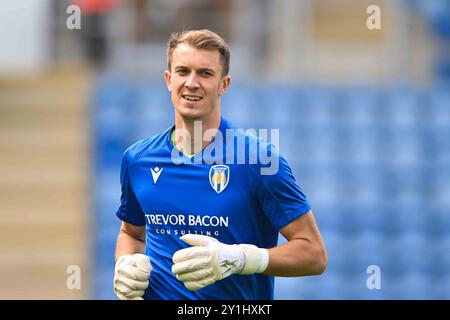 Colchester United goalkeeper Matt Macey (right) punches clear from ...