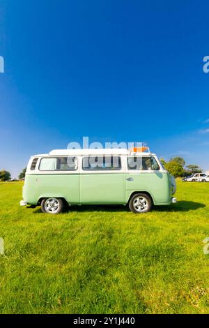 side view green volkswagen bus kombi decorated with rainbow pennants at ...