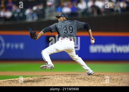 New York Mets pitcher Edwin Díaz, right, looks down while on the mound ...