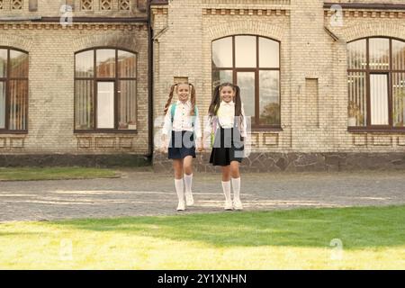 two schoolkids in uniform walking together outdoor Stock Photo - Alamy