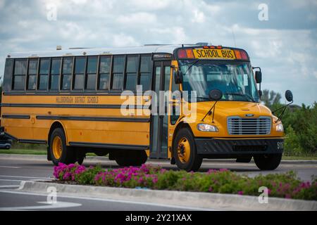 Schoolkid getting on the school bus. American School. Back to school ...