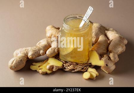 Ginger jam in small square jar and fresh ginger isolated on a white ...