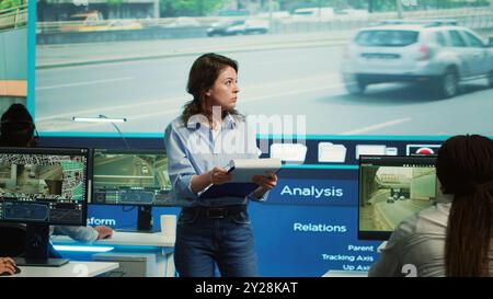 Manager overseeing employees in monitoring traffic activity, operating ...