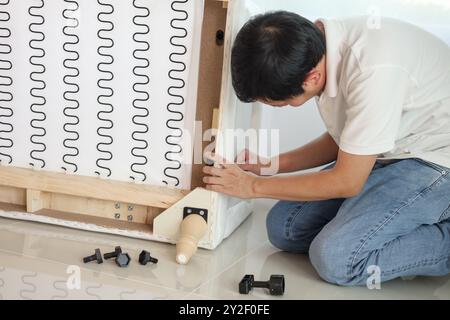Man assembling sofa furniture at home Stock Photo - Alamy