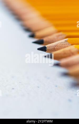 diagonal yellow sharp wooden pencil on a bright yellow background ...