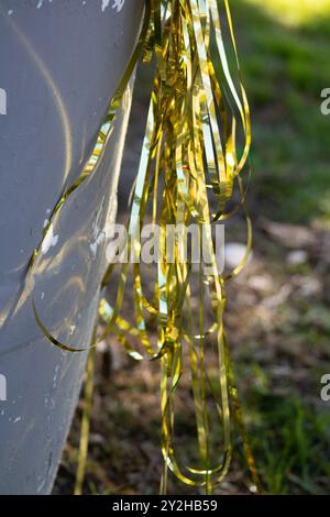 gold celebratory party streamers thrown away in outdoor trash can Stock ...