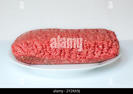 Fresh raw ground beef on wooden cutting board with basil leaves ...
