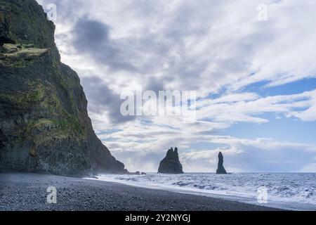 The iconic Reynisdrangar sea stacks rise dramatically from the black ...