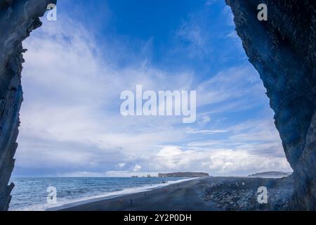 The iconic Reynisdrangar sea stacks rise dramatically from the black ...