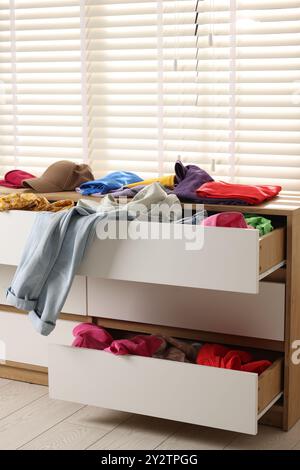 Cluttered chest of drawers indoors. Clothes in mess Stock Photo - Alamy