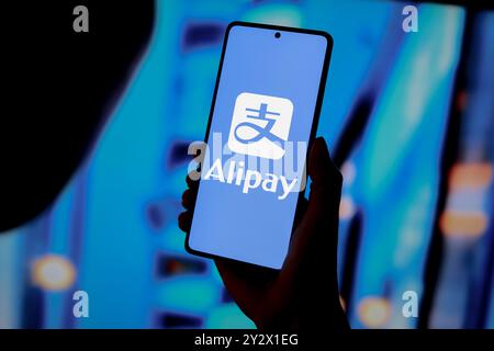 In this photo illustration, Alipay logo is seen on a smartphone and a ...