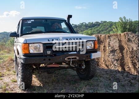 Modified black Land Rover Discovery Series I 4x4 climbing a dusty hill ...