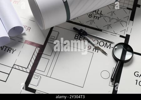 Dividers and magnifying glass on different engineering drawings, top ...
