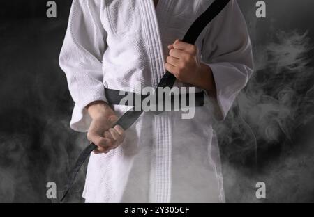 Karate fighter in smoke on black background, closeup Stock Photo - Alamy