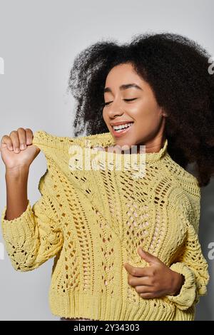 cheerful young woman in yellow T-shirt and jeans with many packets ...