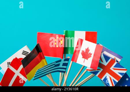 Small paper flags of different countries on light blue background Stock ...