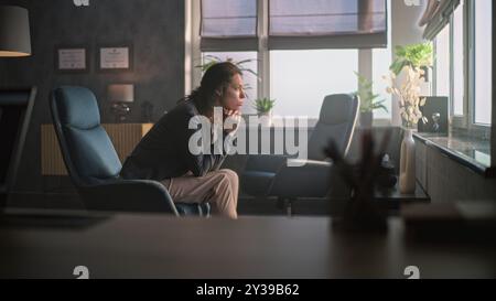 Tired female psychologist sits in chair and rests in stylish ...