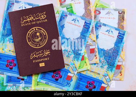 Passport of the State of Qatar issued with Qatari banknotes in currency ...