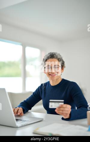 Woman with credit card using laptop at home, closeup Stock Photo - Alamy