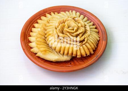 Decorated cake Nakshi Pitha on a clay plate. It is a traditional ...