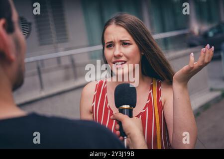 Photo of charming girl giving interview to journalist speaking in ...
