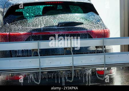 Contemporary vehicle cleaning system applies soapy suds to the rear of ...