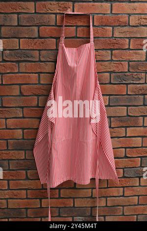 One chef's apron hanging on brick wall Stock Photo - Alamy