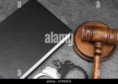 Judge's gavel and handcuffs on gray textured table, flat lay. Space for ...
