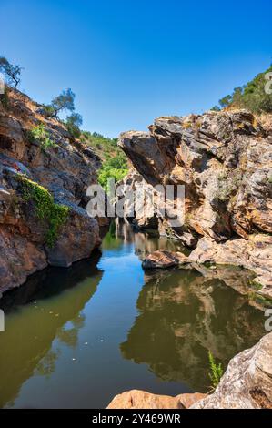 Narrow rocky gorge with still green water at Pego das Pias, a hidden ...