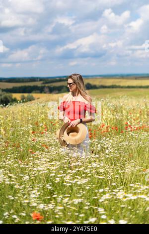 cheerful woman in straw hat looking at camera near haystack in barn ...
