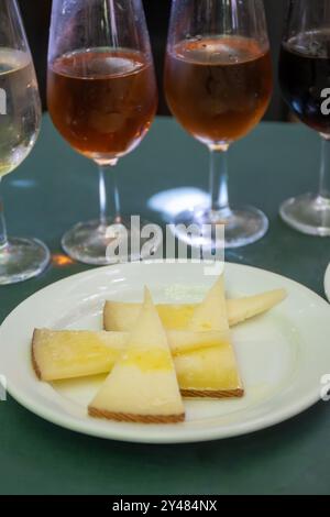 Tasting of Spanish sherry wine and cheeses, triangles of manchego ...