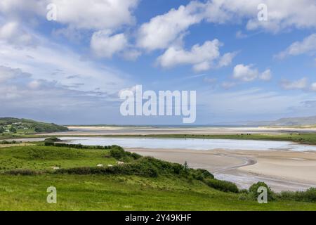 Tidal flat and sandbanks during low tide with sky reflected in shallow ...
