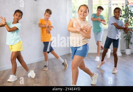 Energetic tween girl practicing vigorous movements in children dance ...