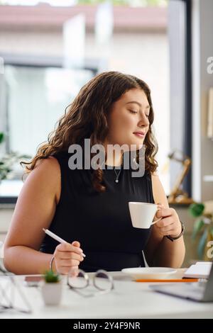 Young woman with curly hair sips coffee at her home office, capturing ...