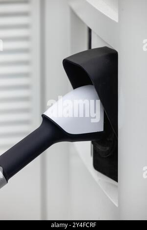 Closeup EV charger handle plugged in or connect to electric car ...