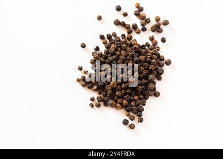 A close-up shot of black pepper balls isolated on a white background ...